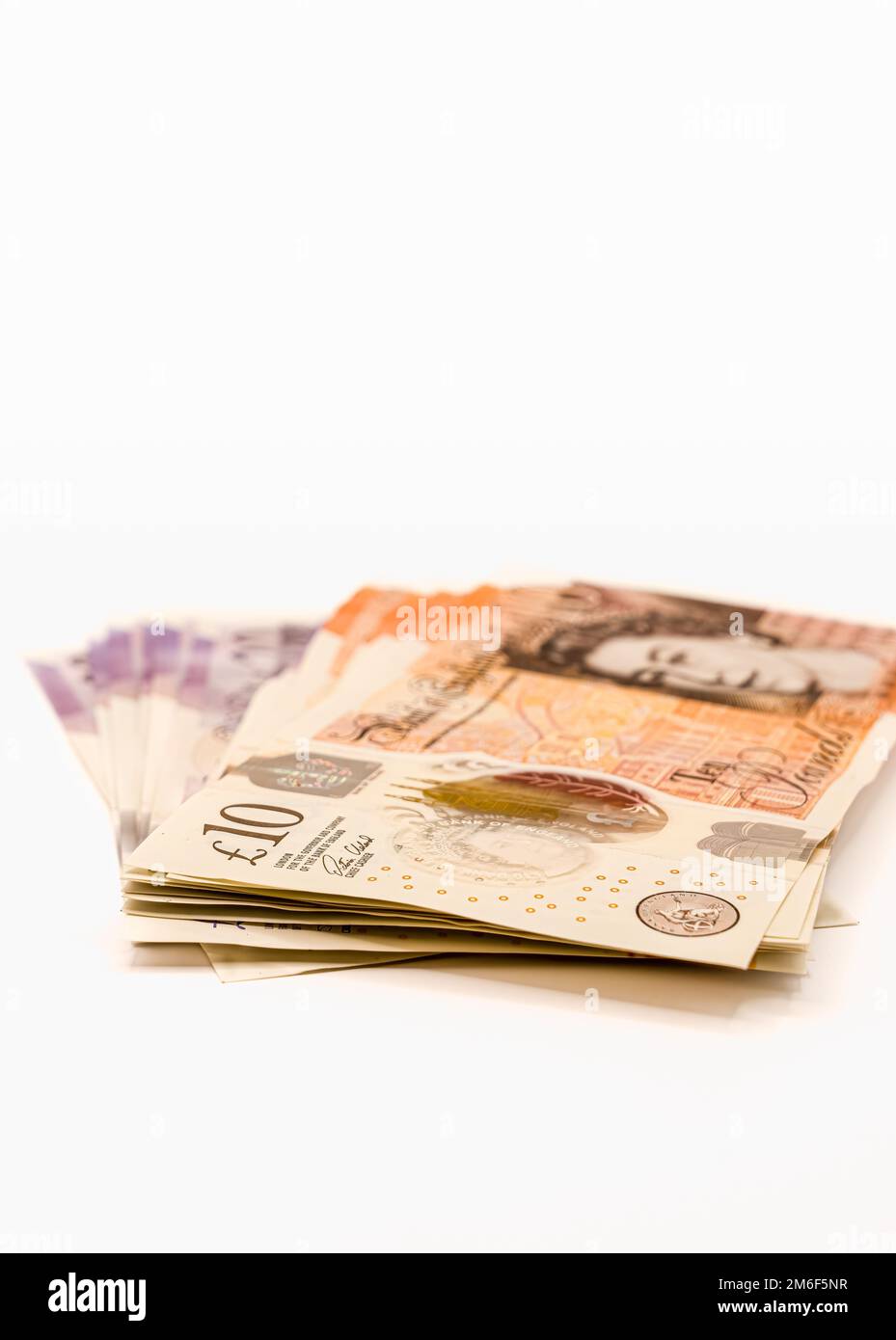 A pile of ten and twenty-pound notes against the white background Stock ...