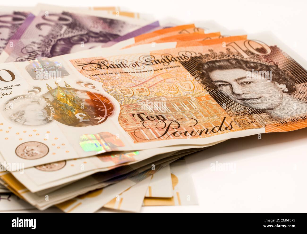 A pile of ten and twenty-pound notes against the white background Stock ...