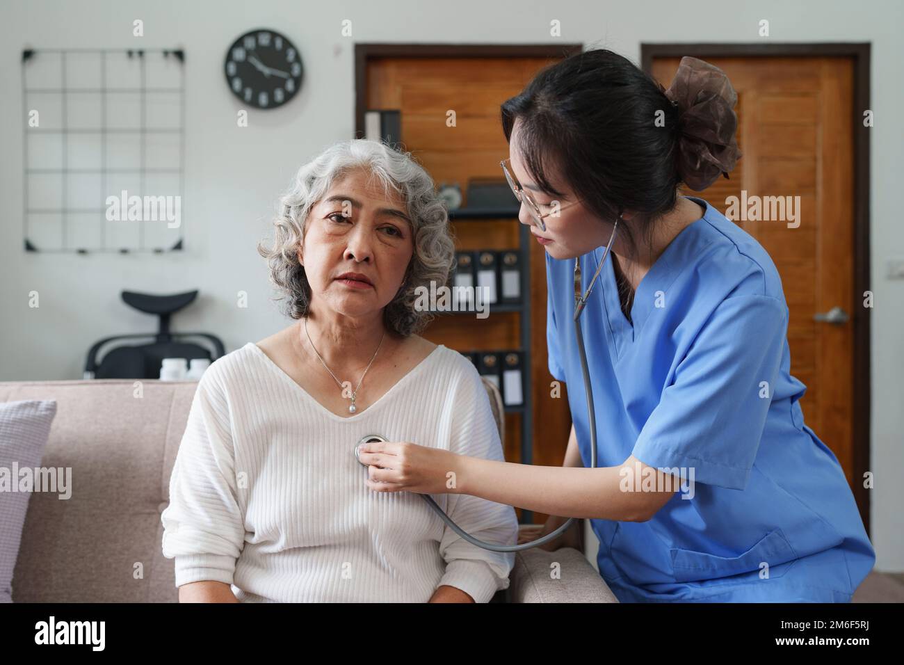 Asian youthful nurse caring for patients or the elderly at home ...