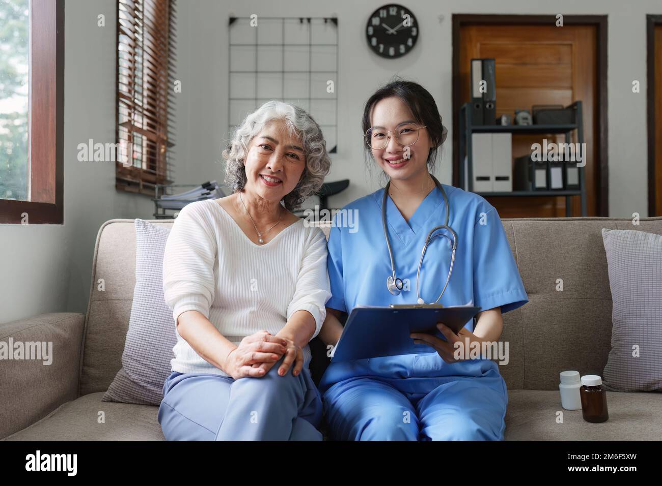 Asian youthful nurse caring for patients or the elderly at home ...