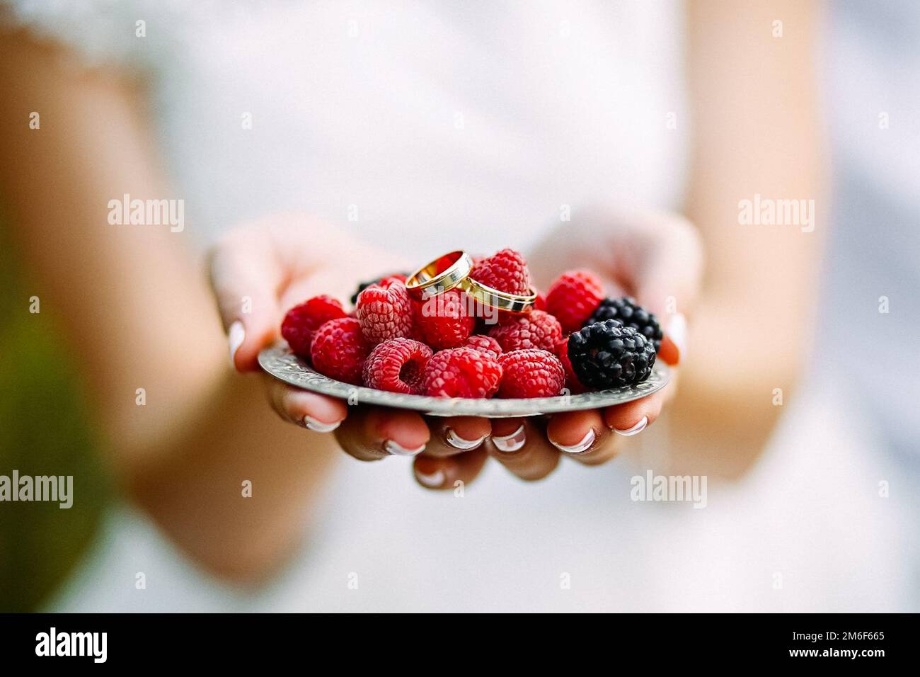 Wedding koets on plate with raspberry berries Stock Photo - Alamy