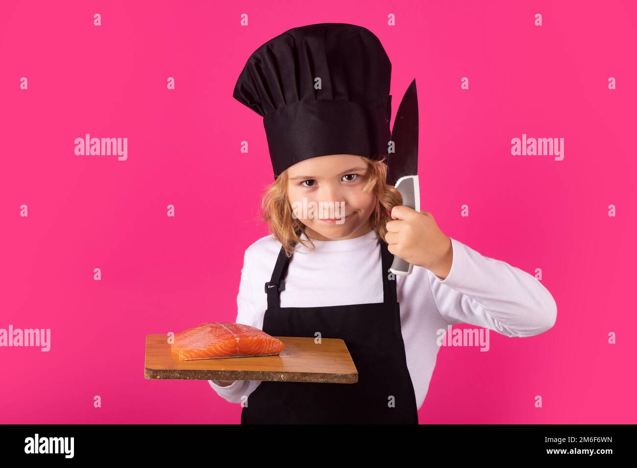 Kid cook hold cutting board with fish salmon steak and knife. Kid chef ...