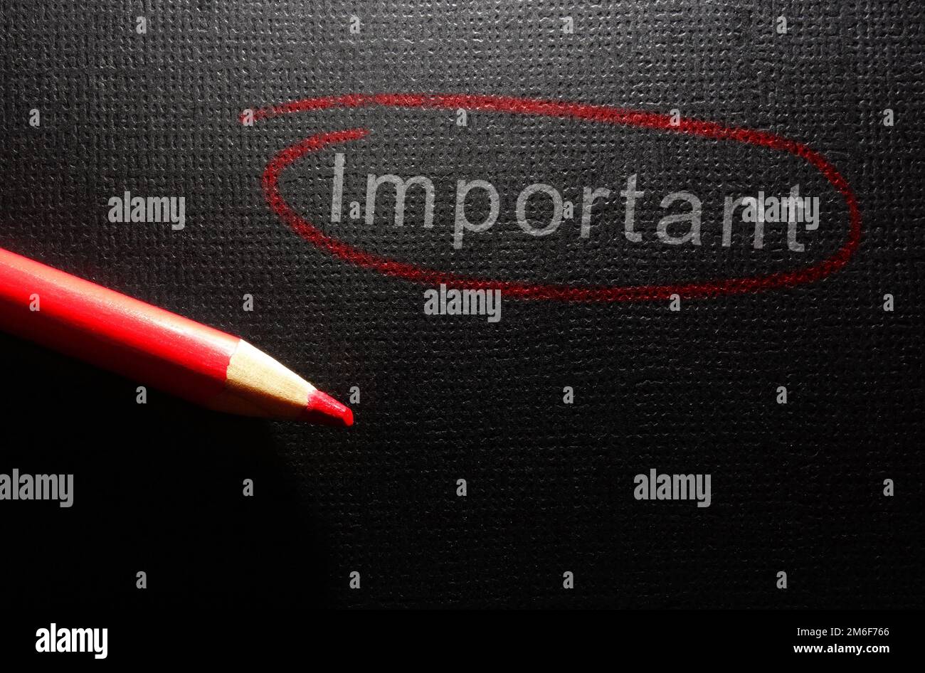 Important text circled in red pencil on black textured paper background ...