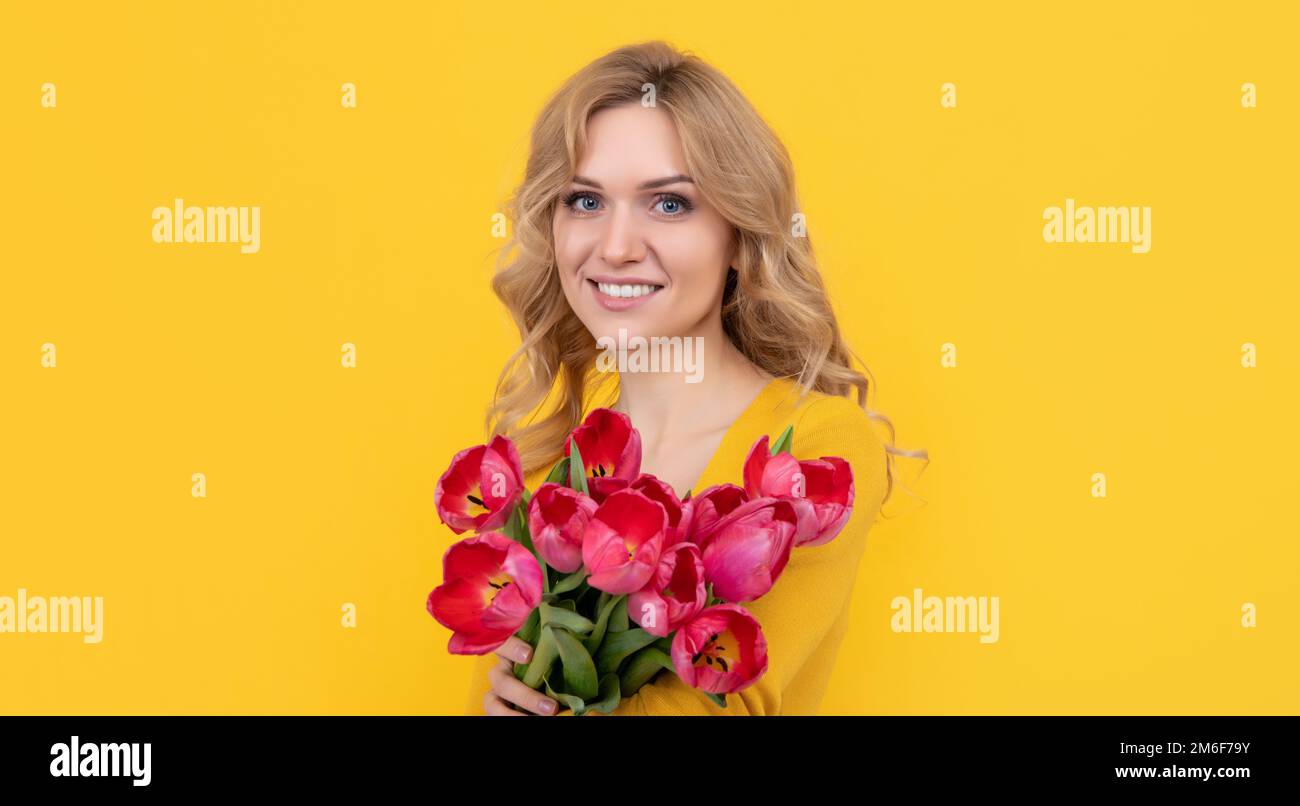 happy young girl with spring tulip flowers on yellow background Stock ...
