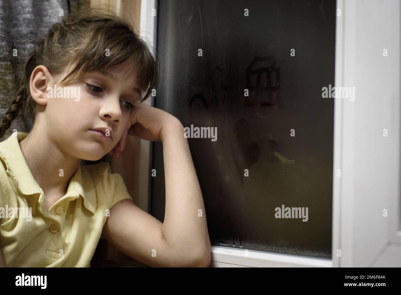 A frustrated girl sits at a foggy window and is sad Stock Photo - Alamy