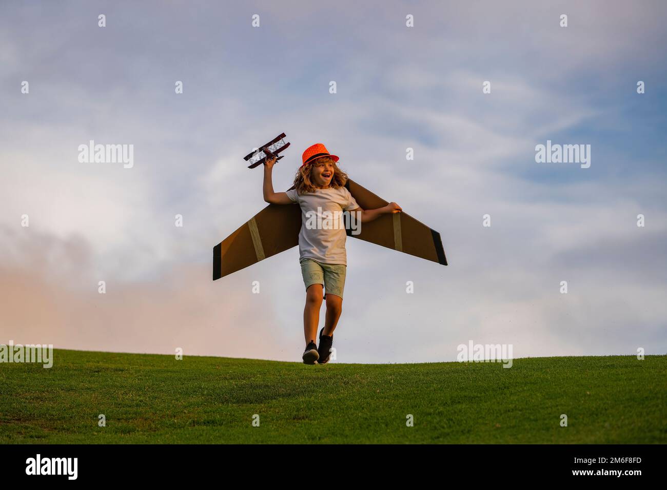Happy childhood. Kid having fun with toy airplane in field. Child pilot ...