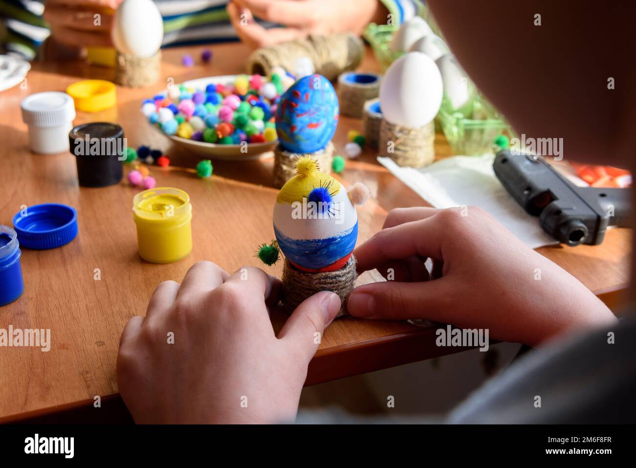 The child's hands are carefully holding toys from eggs for the Easter ...