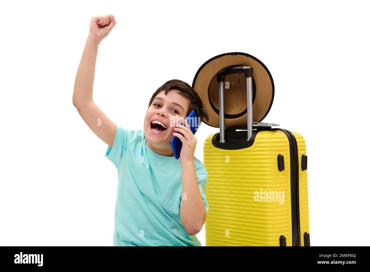 Overjoyed teen boy clenching fist while having a phone conversation ...
