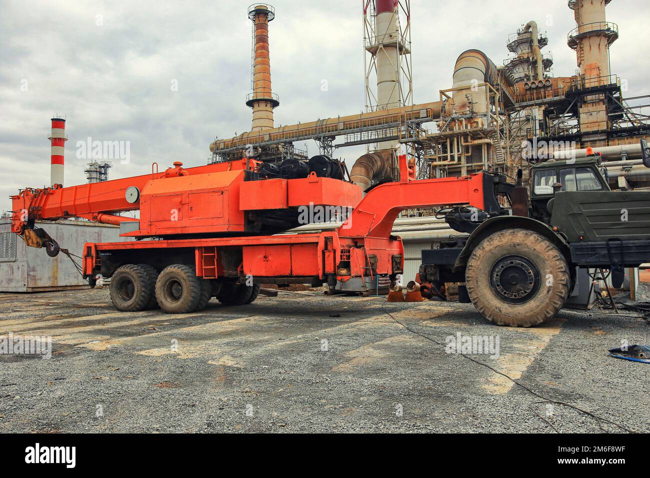 A heavy-duty truck crane with a folded boom stands on the industrial ...