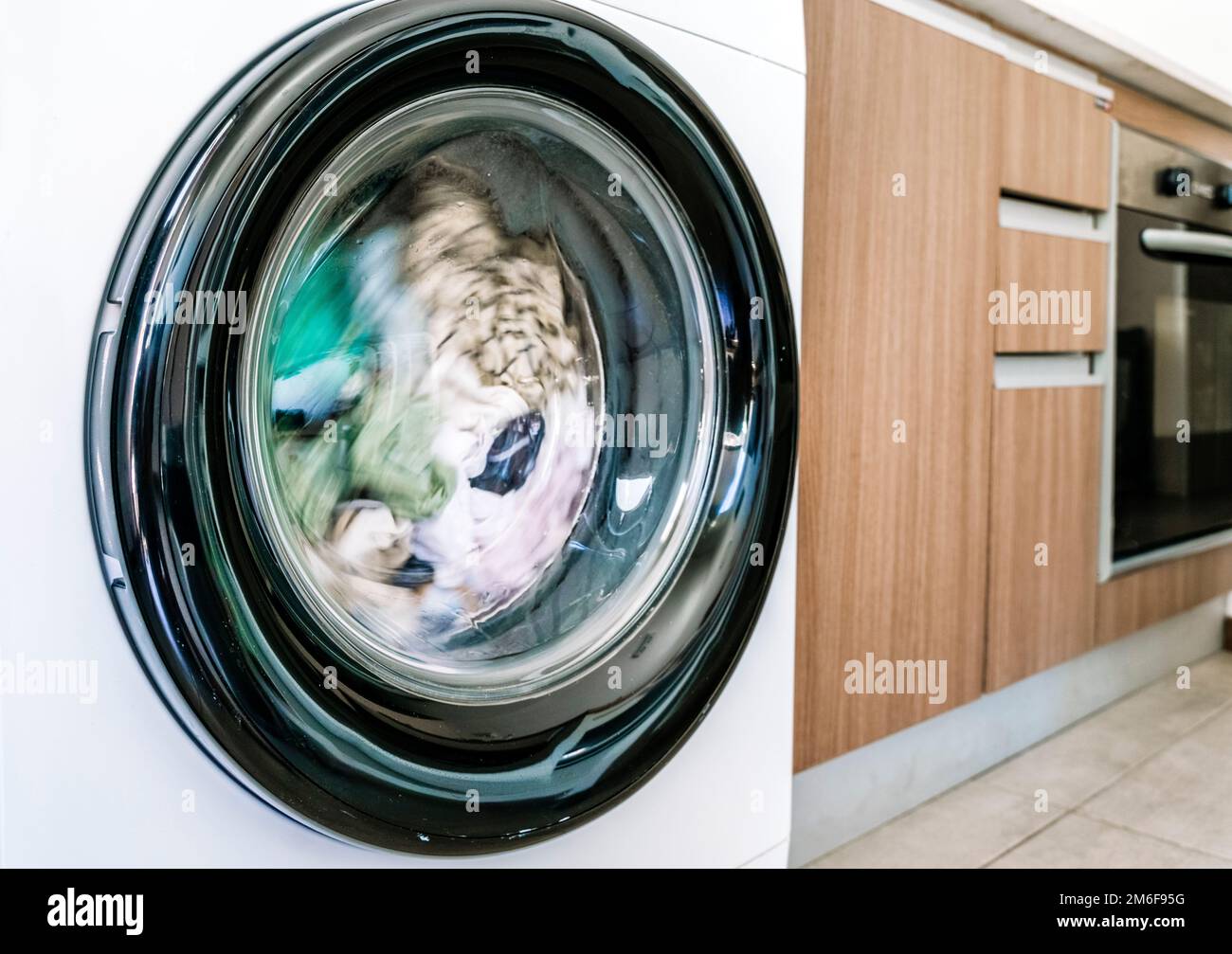 Washing machine with clothes in interior of the laundry room at home ...