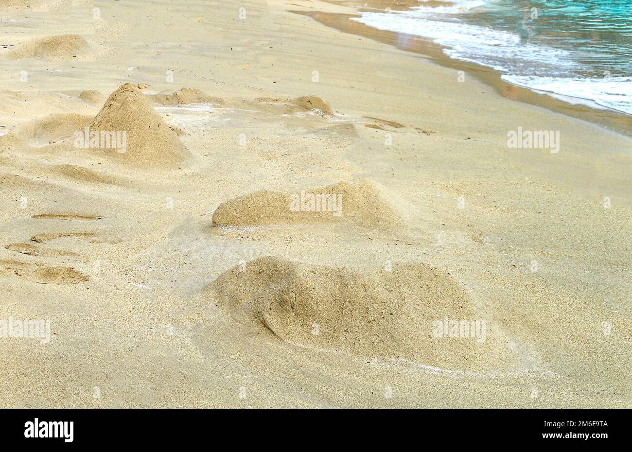 A lot of sand and building houses on the beach, children's creativity ...