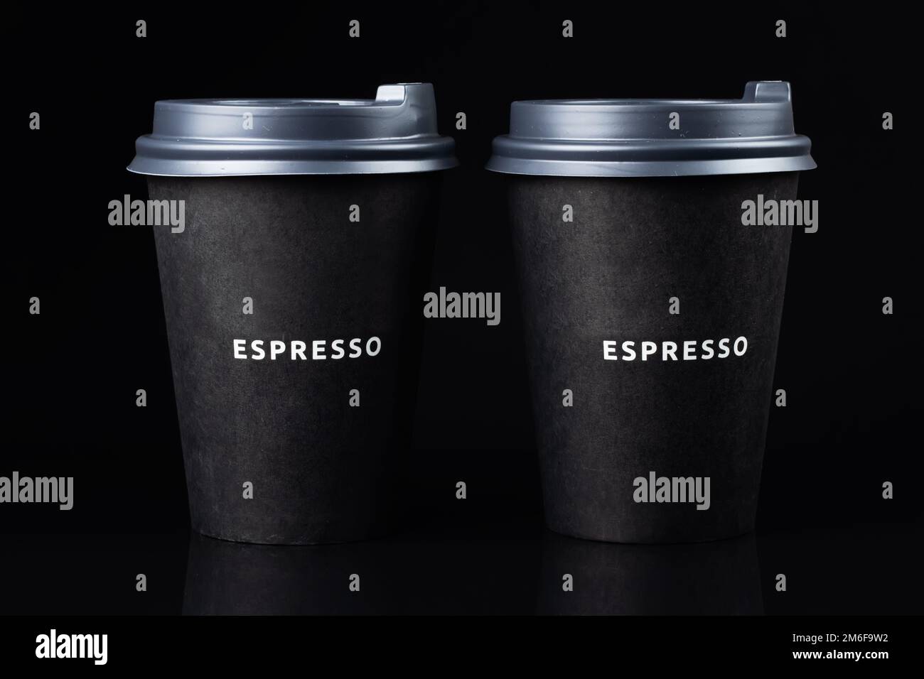 two black paper coffee cup isolated on black background Stock Photo - Alamy