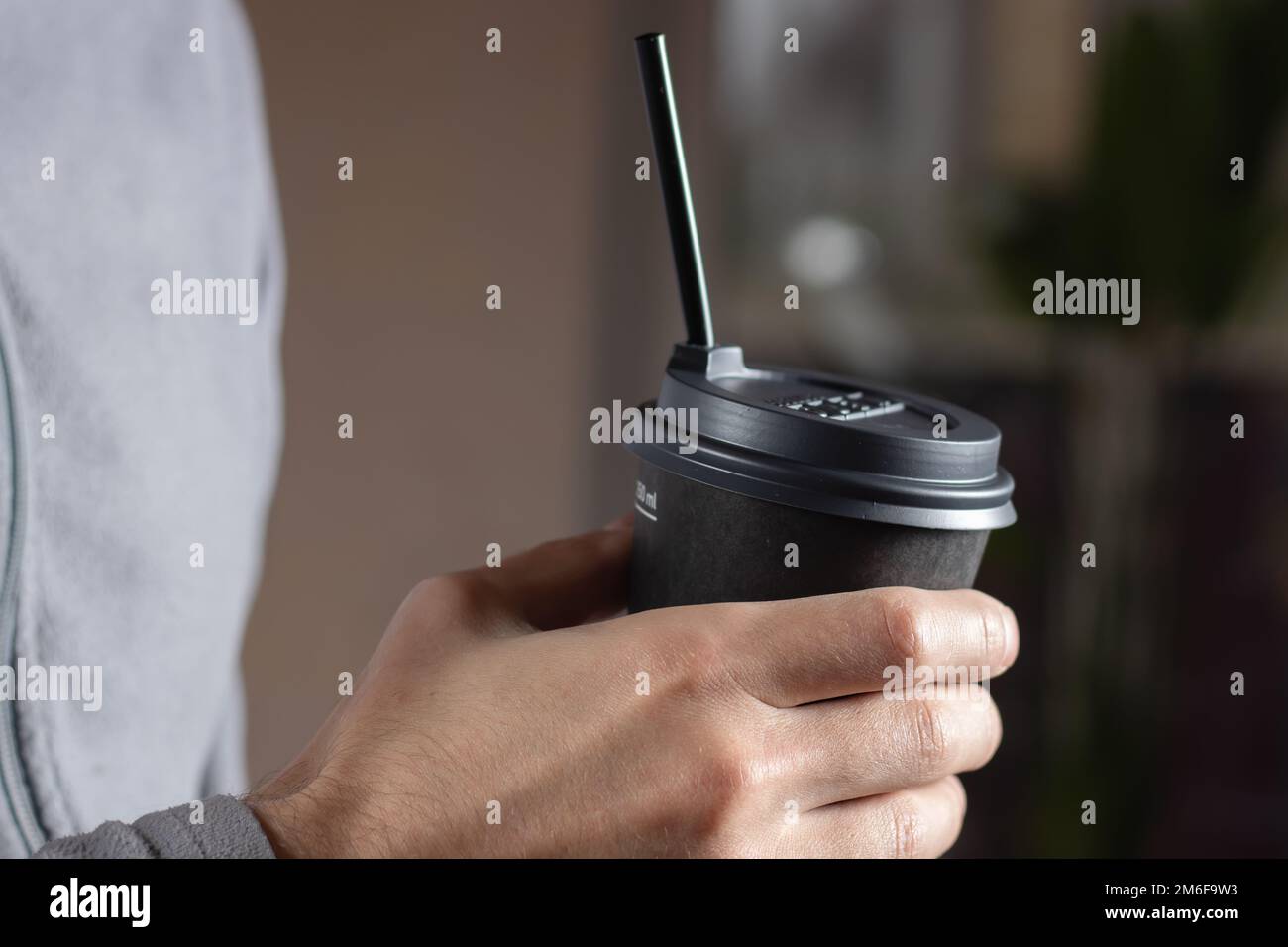 Man drinking coffee from disposable cup with cocktail tube close up ...