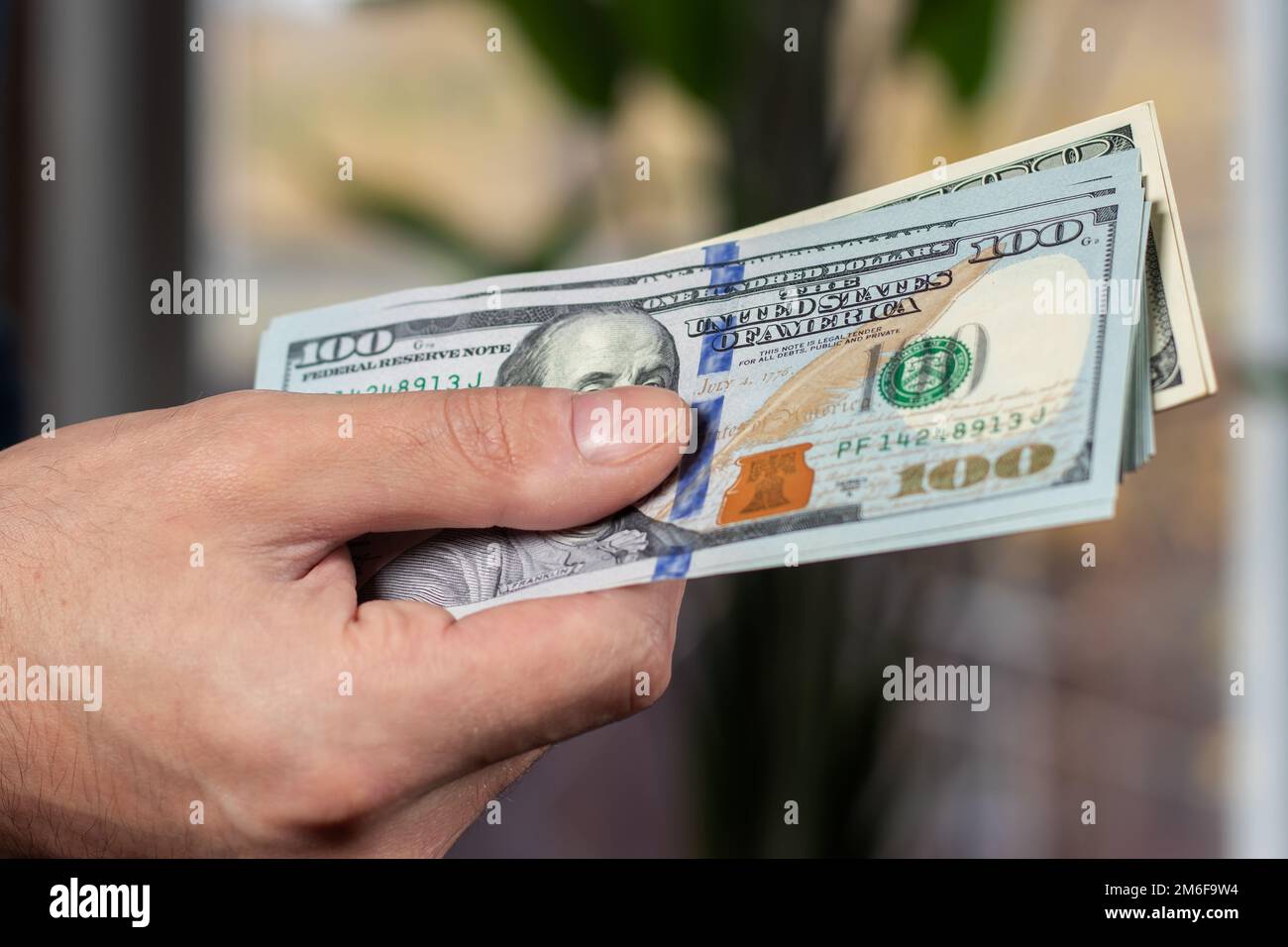 American 100 dollars bank note in hand close up Stock Photo - Alamy