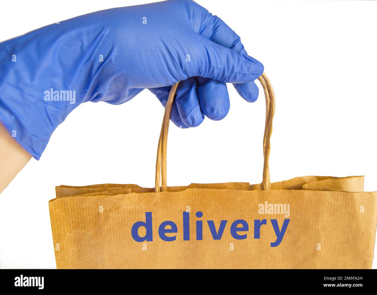 A hand in a blue rubber glove holds a paper bag labeled DELIVERY, fast ...