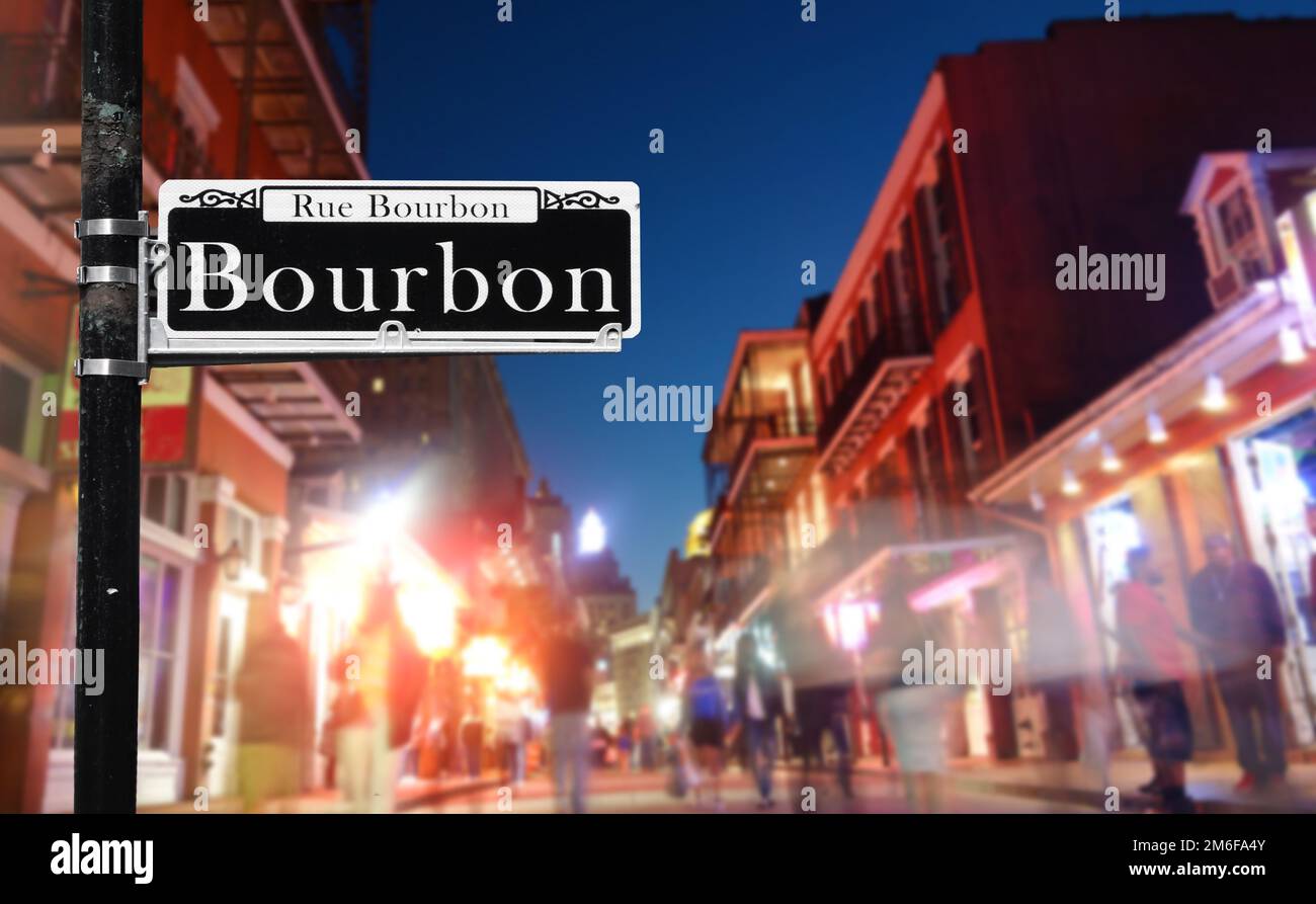 Tourists walk along Bourbon St in New Orleans French Quarter at night ...