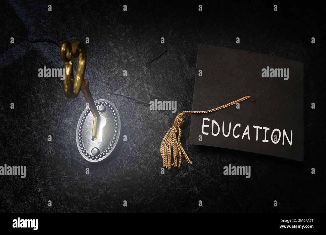 Gold education key and graduation cap Stock Photo - Alamy