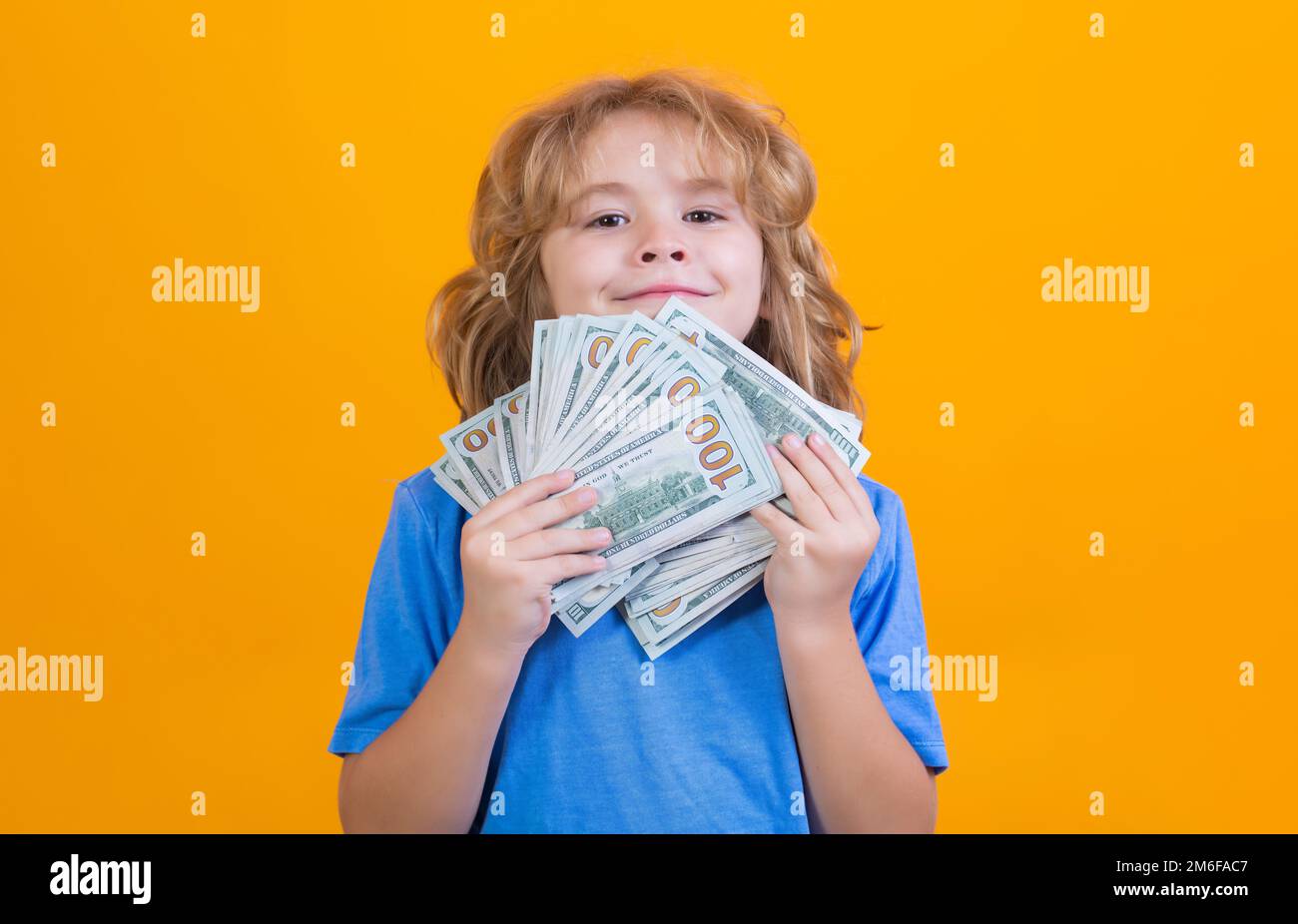 Kid showing money dollar bills, standing dreamy of rich against ...