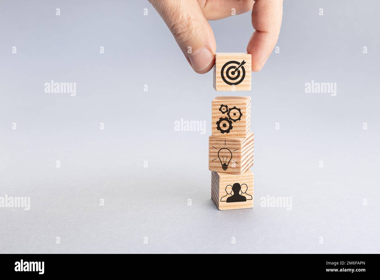 Business team strategy and action plan concept. Hand putting wood block with target icon on top ...