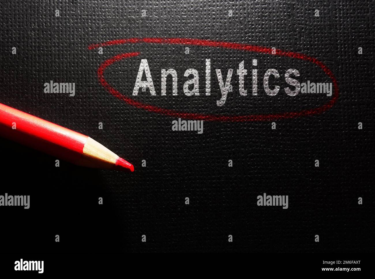 Analytics text circled in red pencil on dark textured surface Stock ...