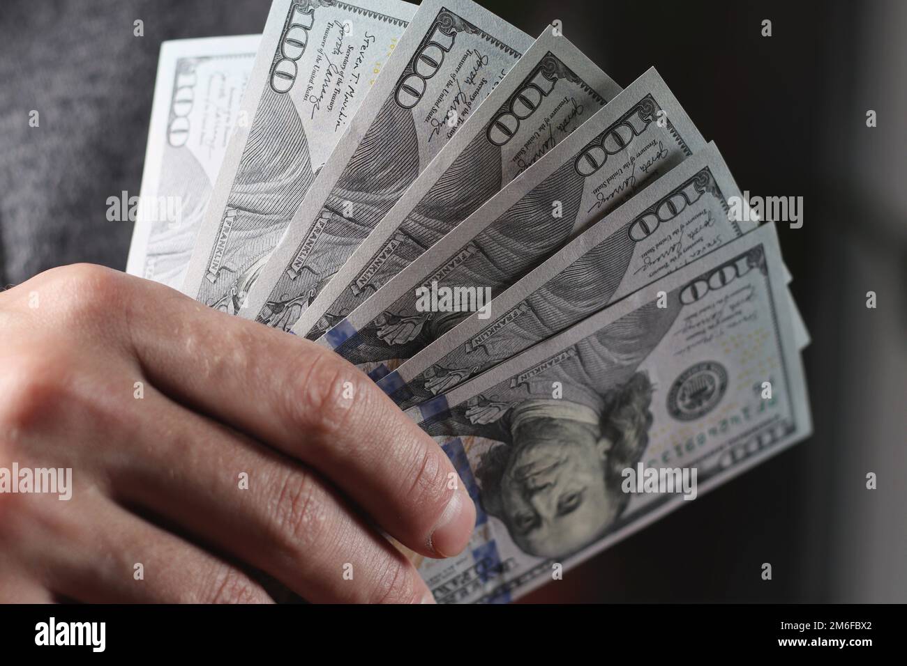 Men's hand holds a fan of dollars close up Stock Photo - Alamy