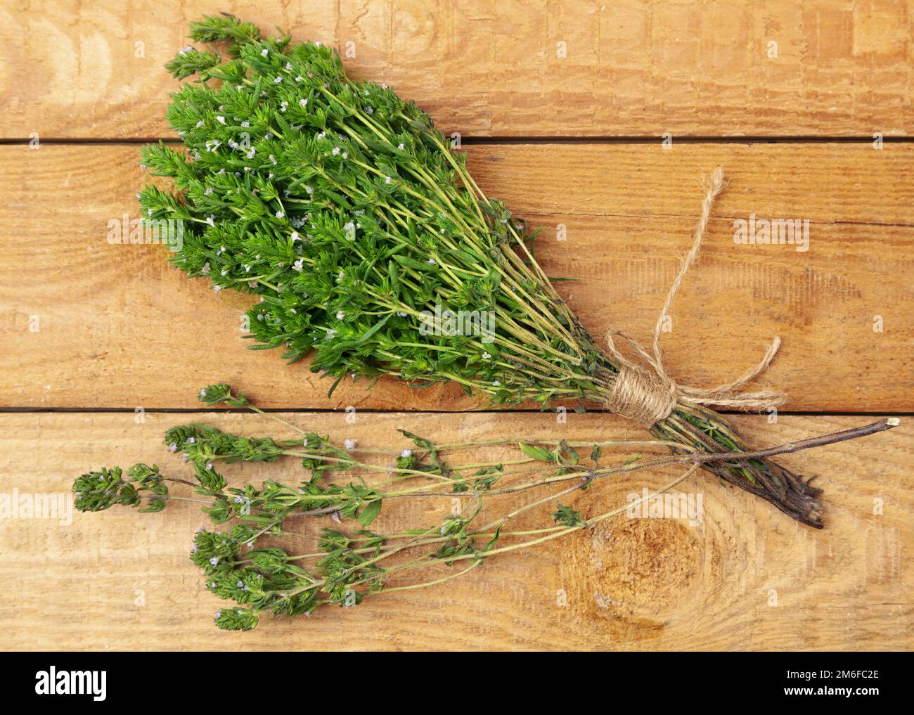 Bunch of thyme twigs isolated on wooden table Stock Photo - Alamy