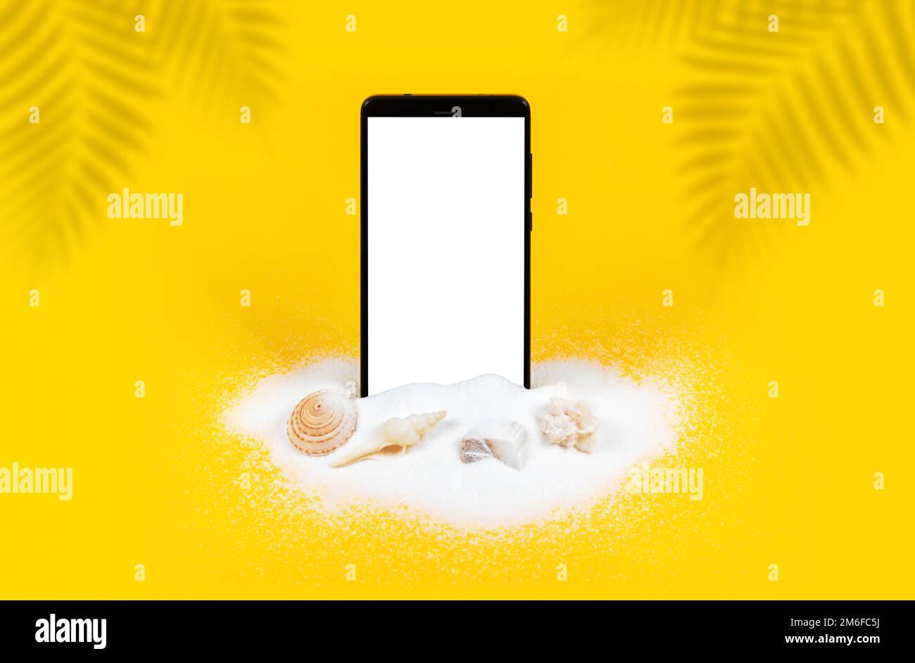 Smartphone with empty screen in sand and shells on yellow background ...