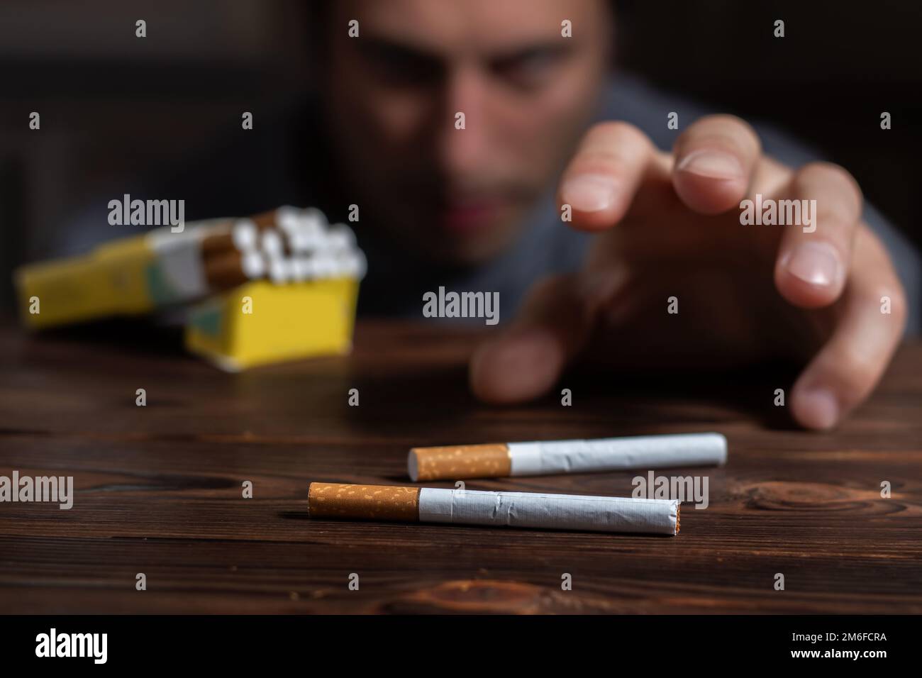 Cigarettes. The concept of nicotine addiction. The man reaches for his ...