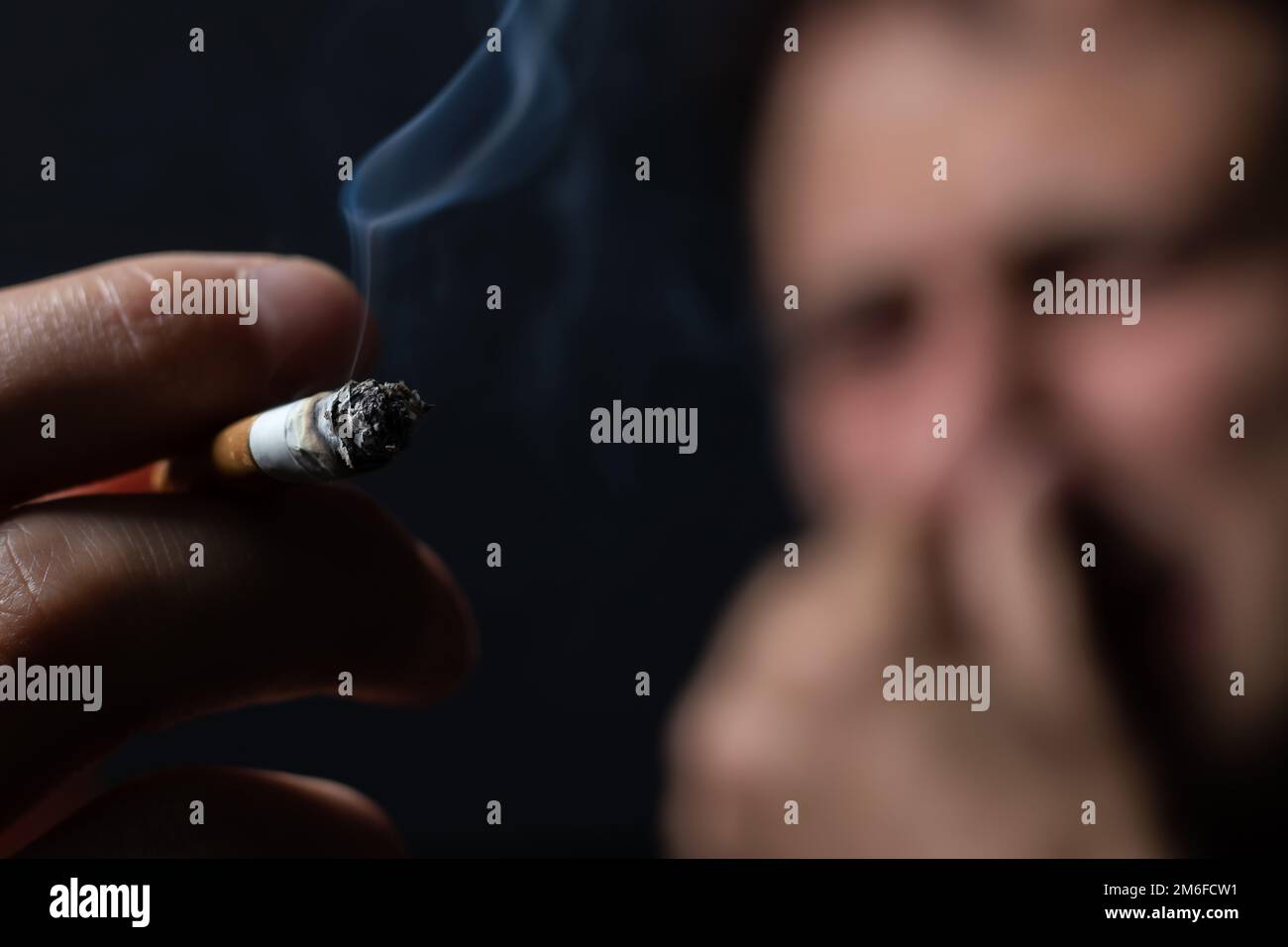 Passive smoking concept. Man is smoking cigarette and man is covering ...