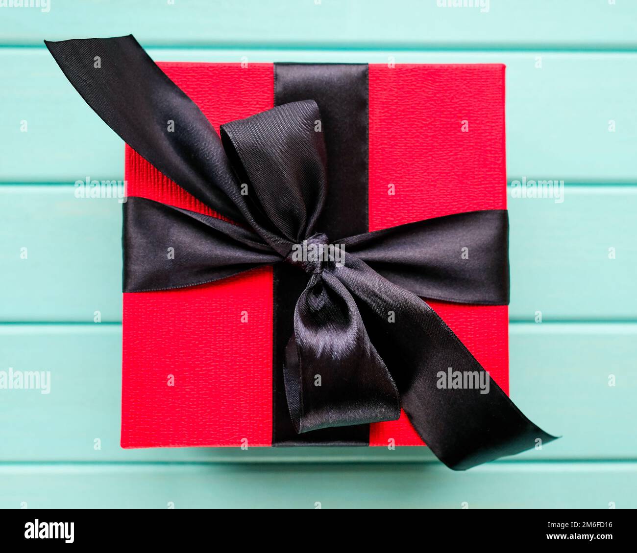 The red square box is tied with a black ribbon. Blue background ...