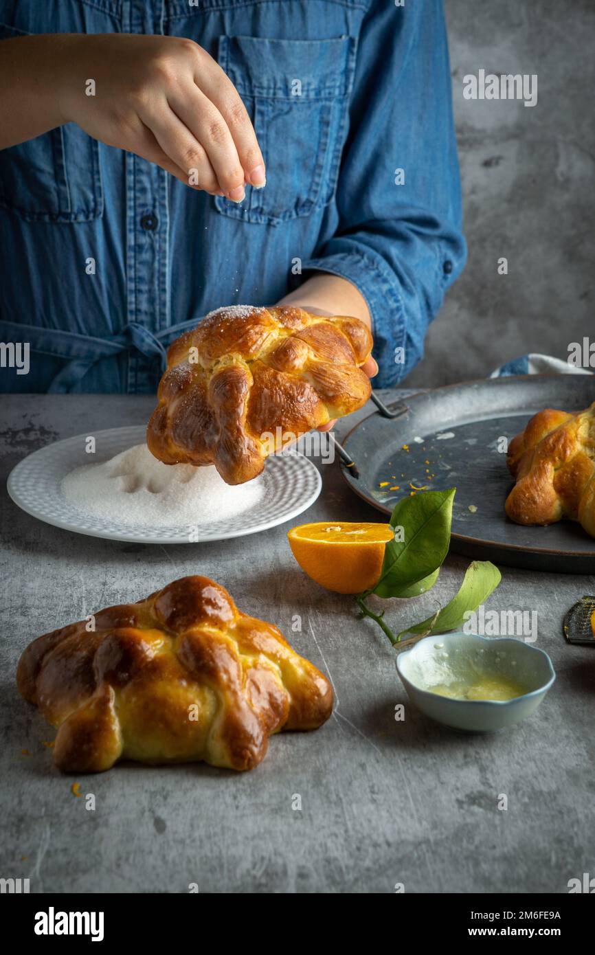 Woman preparing Pan de muertos bread of the dead for Mexican day of the ...