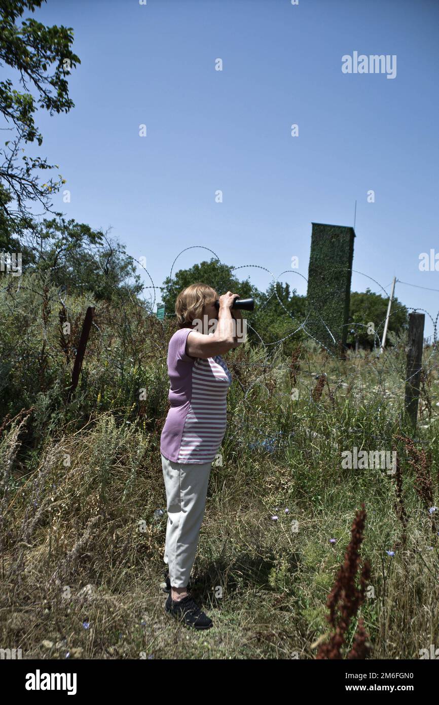 Luda salia (63), standing in front of barbwire fences, which divides ...