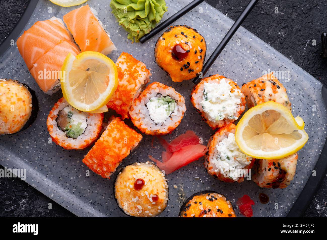 Sushi roll set served at grey tray at black table. flat lay. close up ...