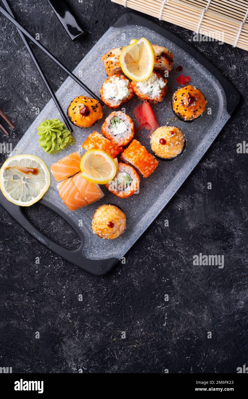 Sushi roll set served at grey tray at black table. flat lay. close up ...