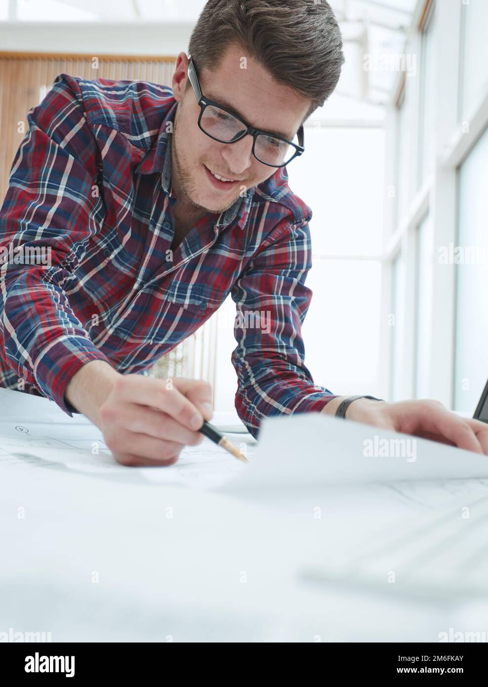 Close-up of engineers hands with pens over blueprints with sketches of ...