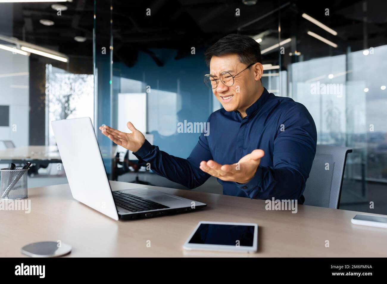 Angry and upset asian businessman, man working with laptop unhappy with ...