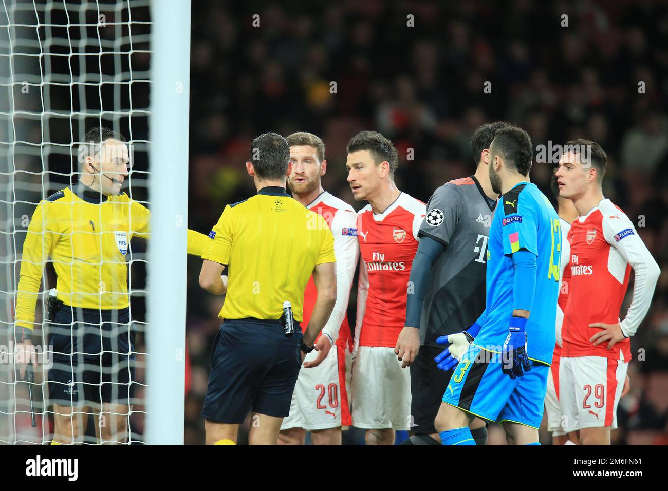 Arsenal players argue with the referee as he shows Laurent Koscielny of ...