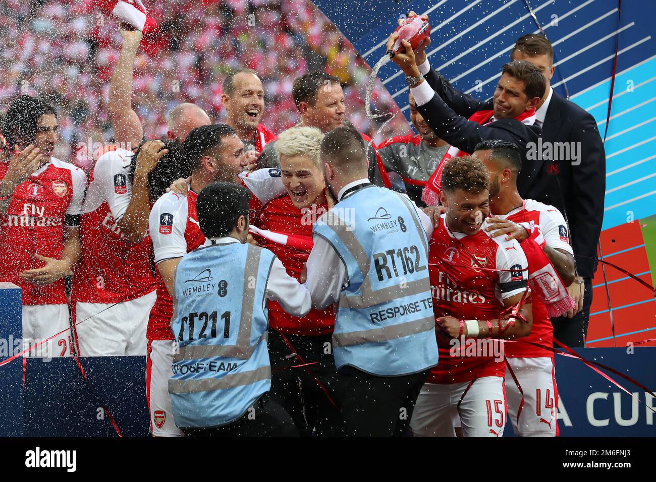 A fan is lead away by stewards after invading the pitch to celebrate ...