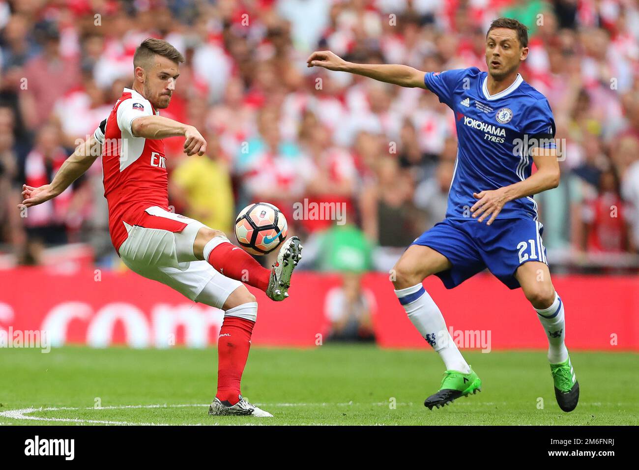 Aaron Ramsey of Arsenal control the ball under pressure from Nemanja ...