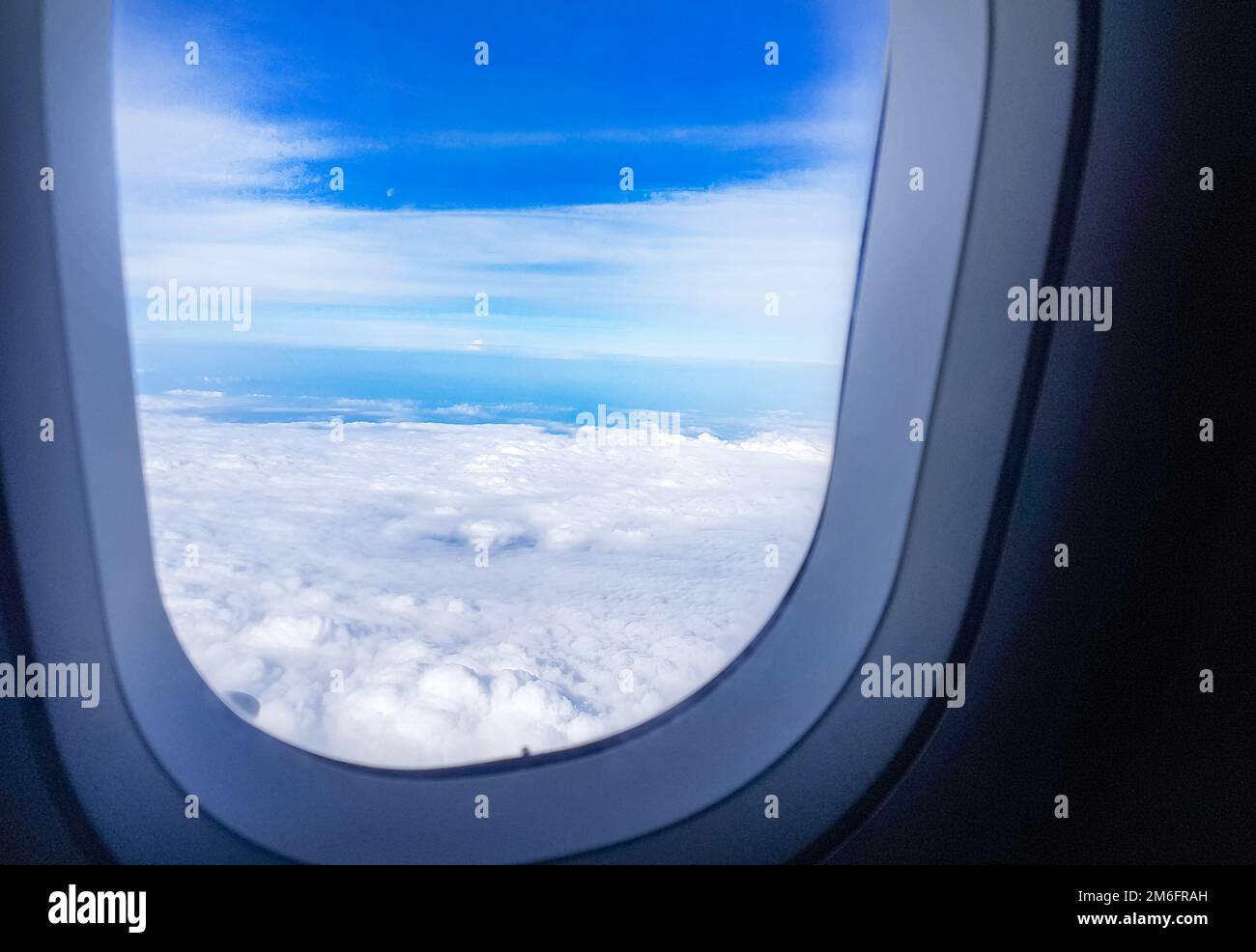 The view from the round window of the plane on the white snow clouds ...