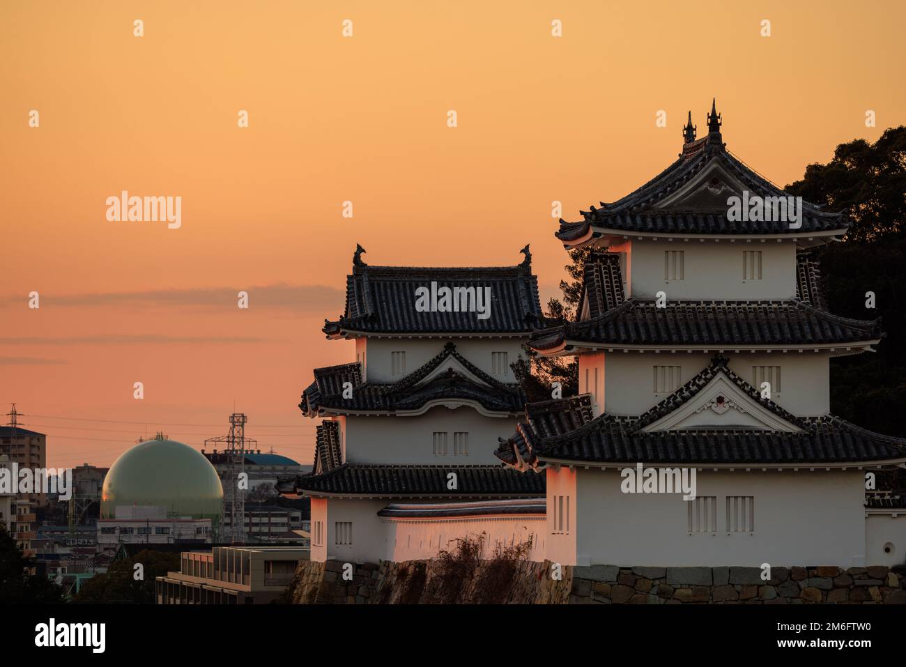 Sunset light hits historic Japanese castle near spherical liquid ...