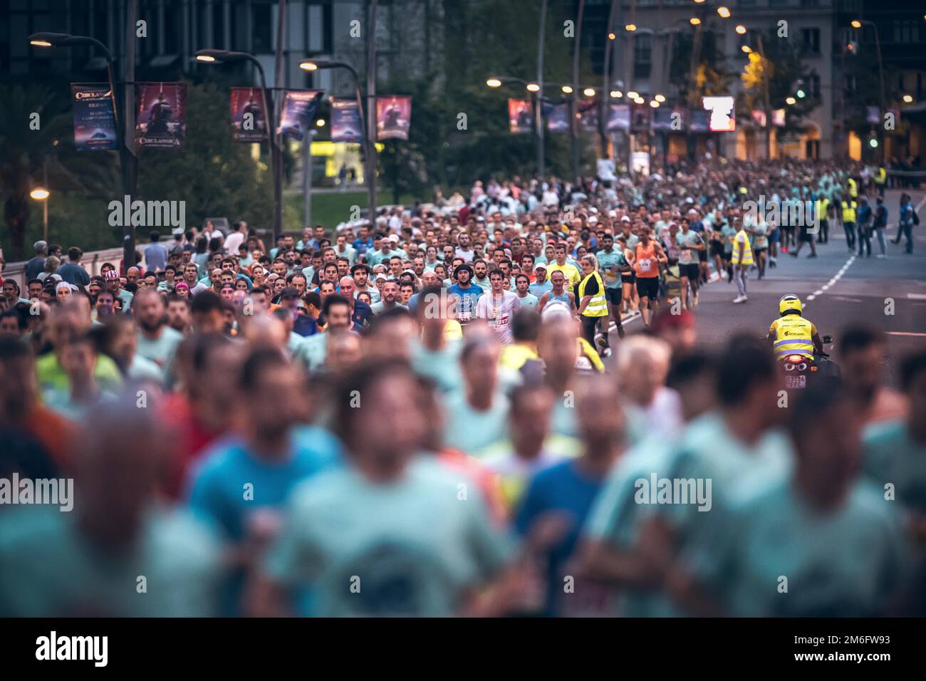 Many runners in the Bilbao Night Marathon, running in the streets of ...