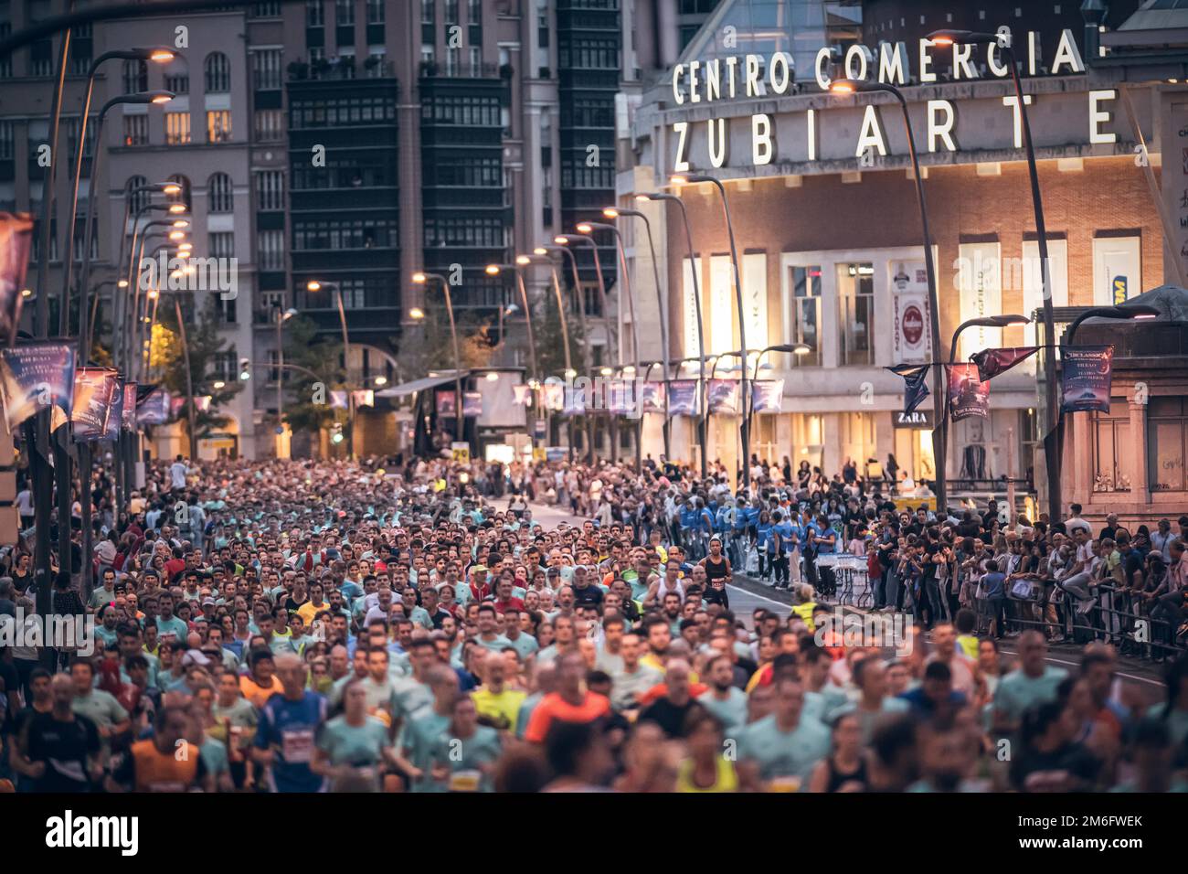Many runners in the Bilbao Night Marathon, running in the streets of ...