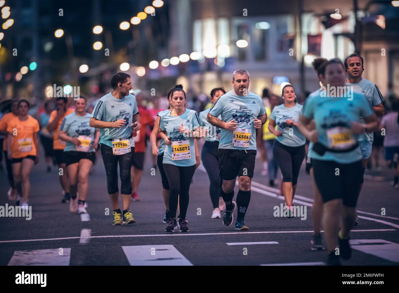 Many runners in the Bilbao Night Marathon, running in the streets of ...