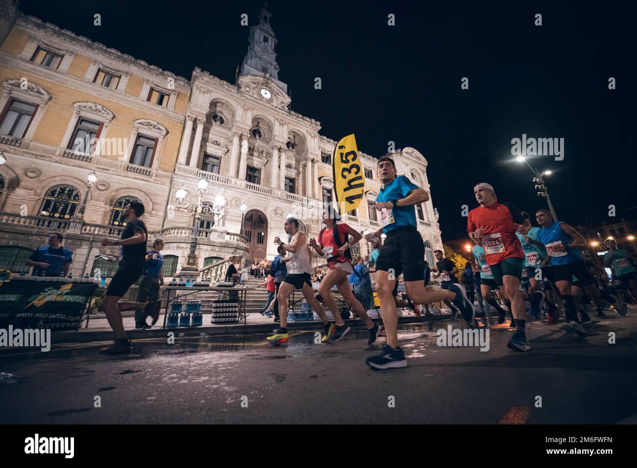 Many runners in the Bilbao Night Marathon, running in the streets of ...