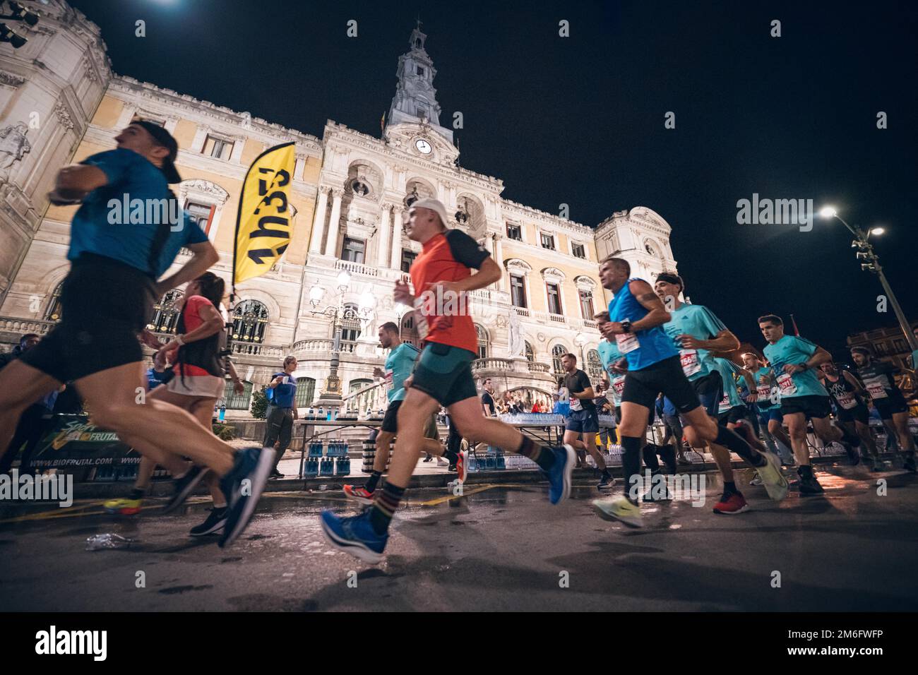 Many runners in the Bilbao Night Marathon, running in the streets of ...