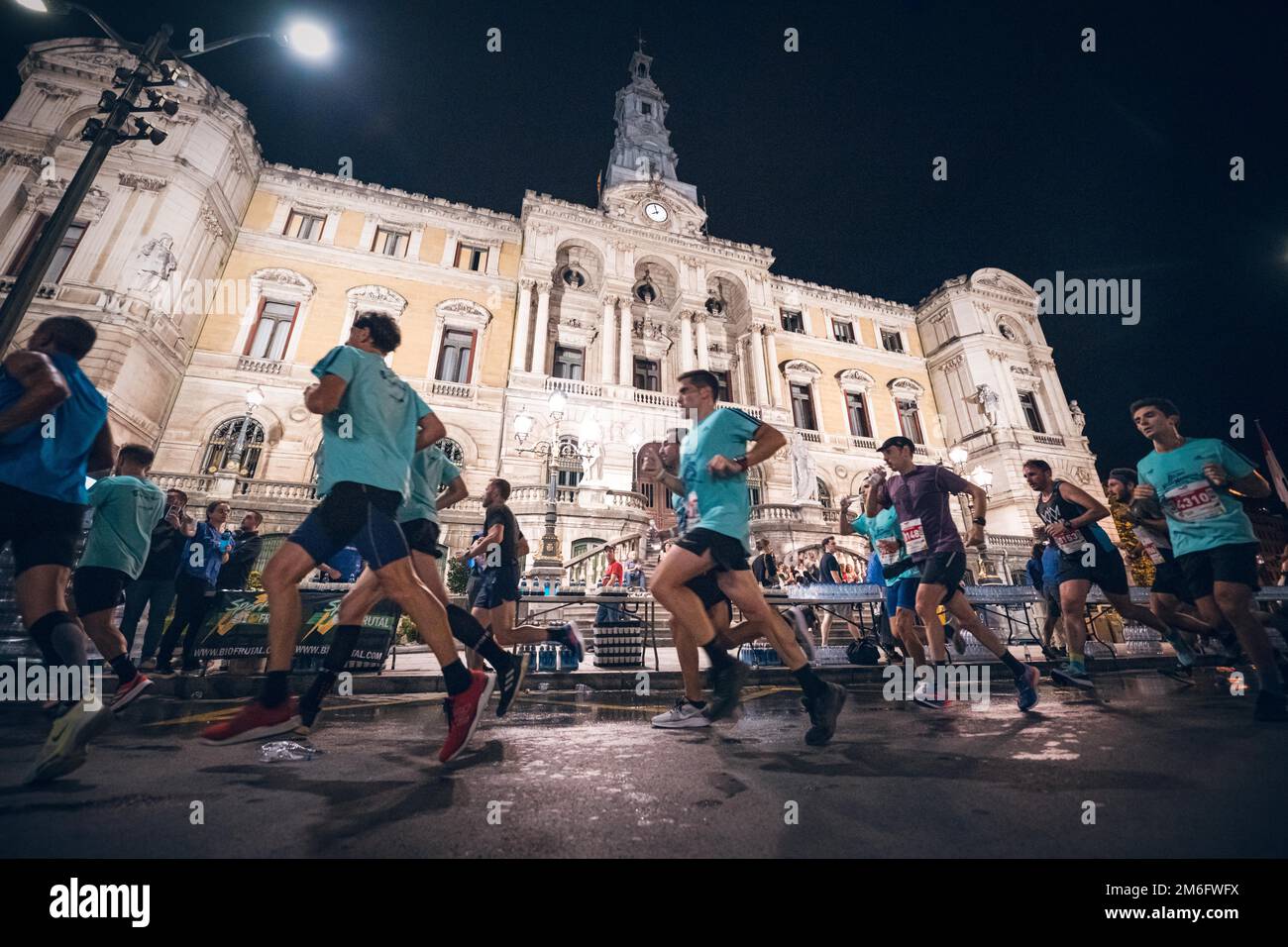 Many runners in the Bilbao Night Marathon, running in the streets of ...