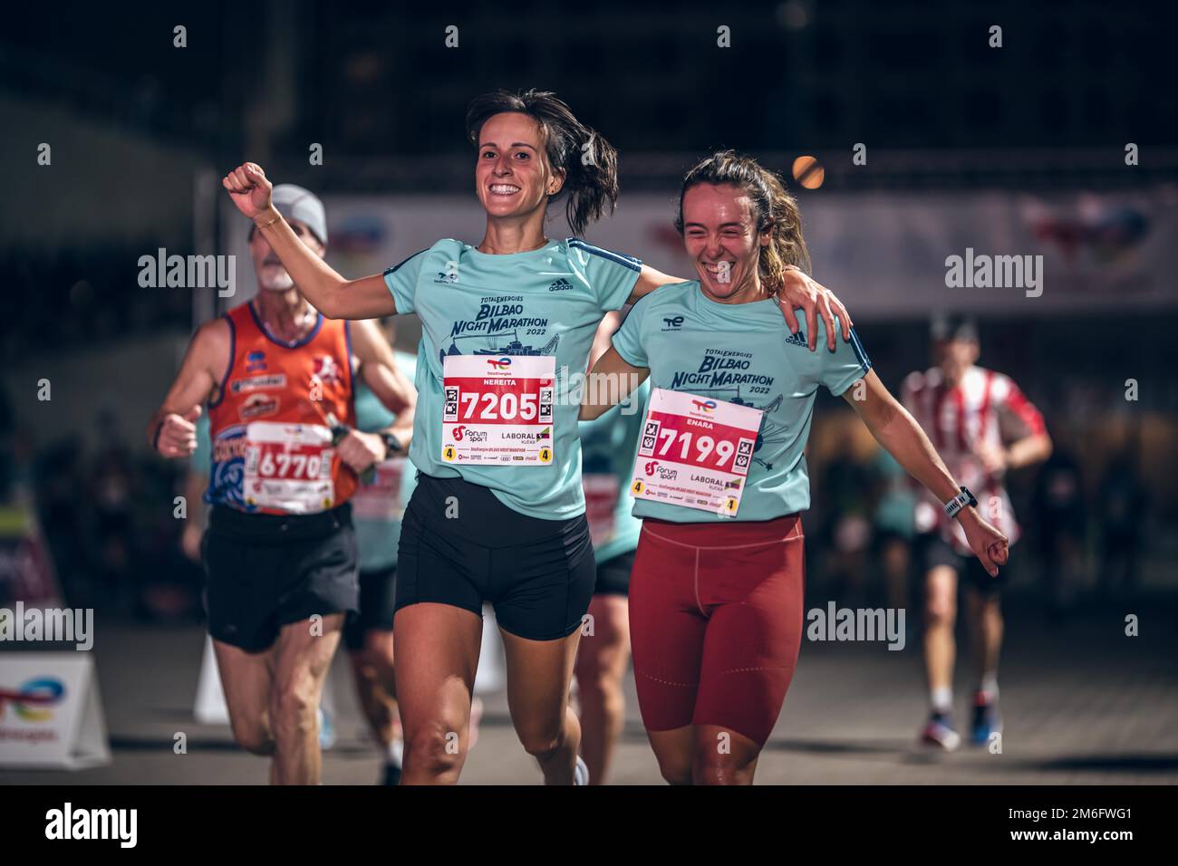 Two girls reaching the finish line in the Bilbao Night Marathon ...