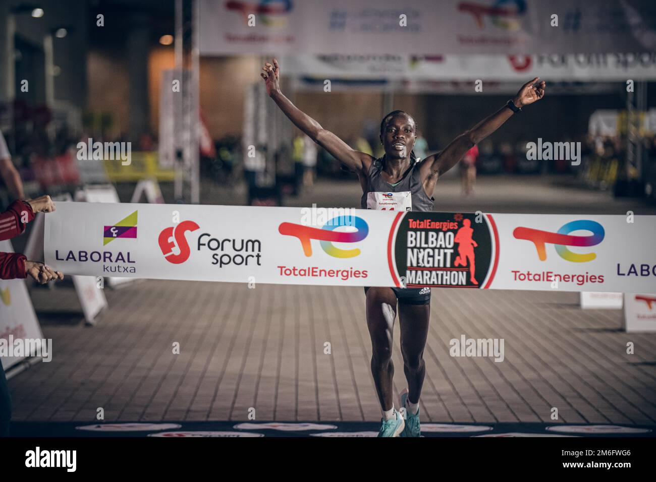 Winners at the finish line in the Bilbao Night Marathon, running ...