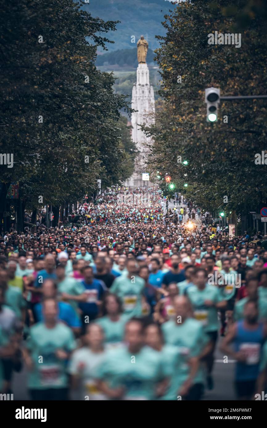 Many runners in the Bilbao Night Marathon, running in the streets of ...